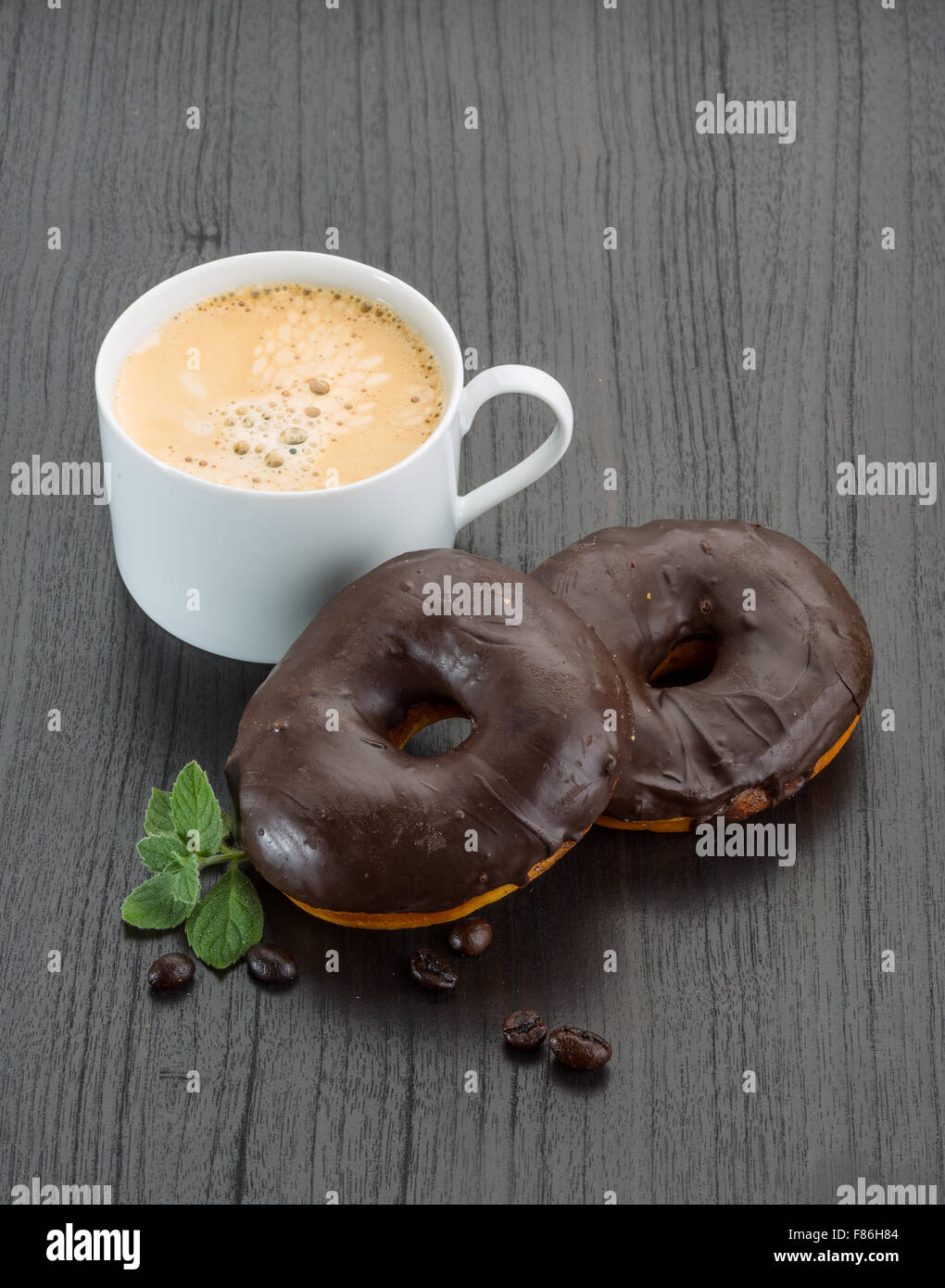 Chocolate donuts with coffee on the desk Stock Photo - Alamy