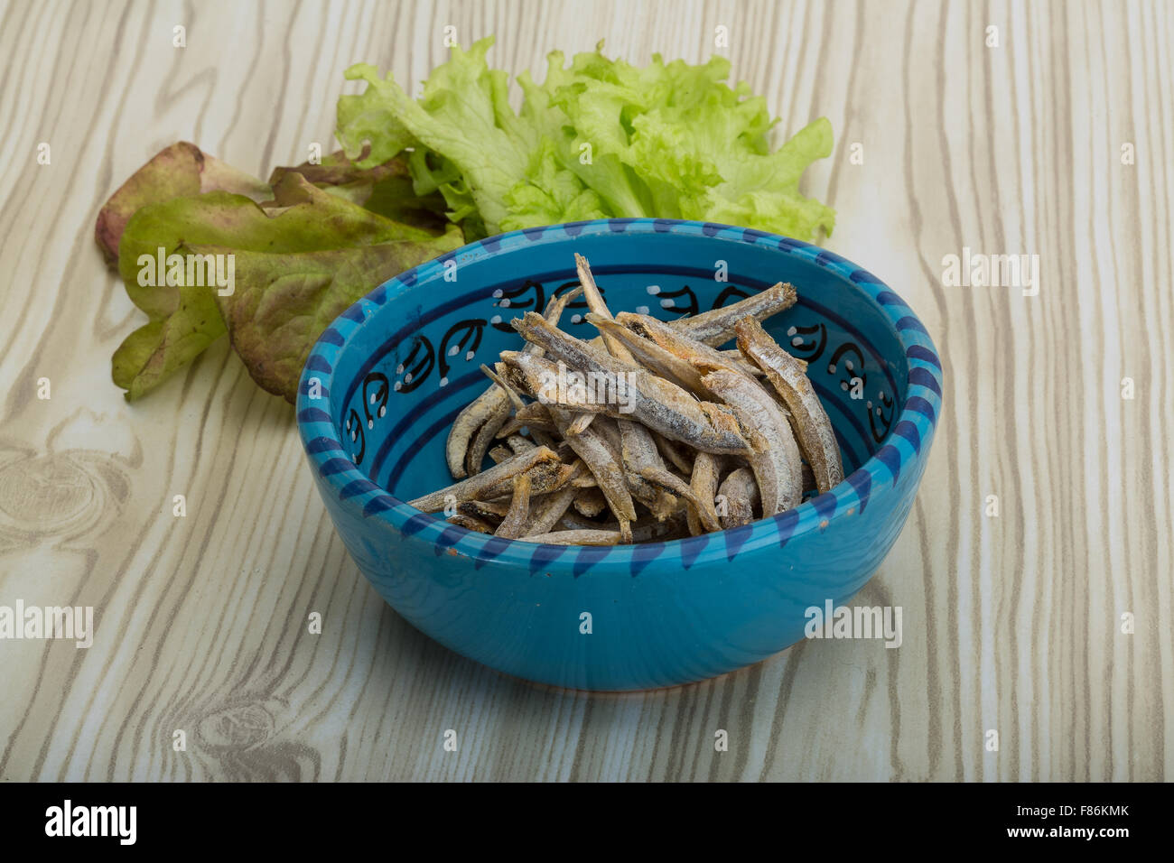Dries anchovy - small fishes in the bowl Stock Photo - Alamy