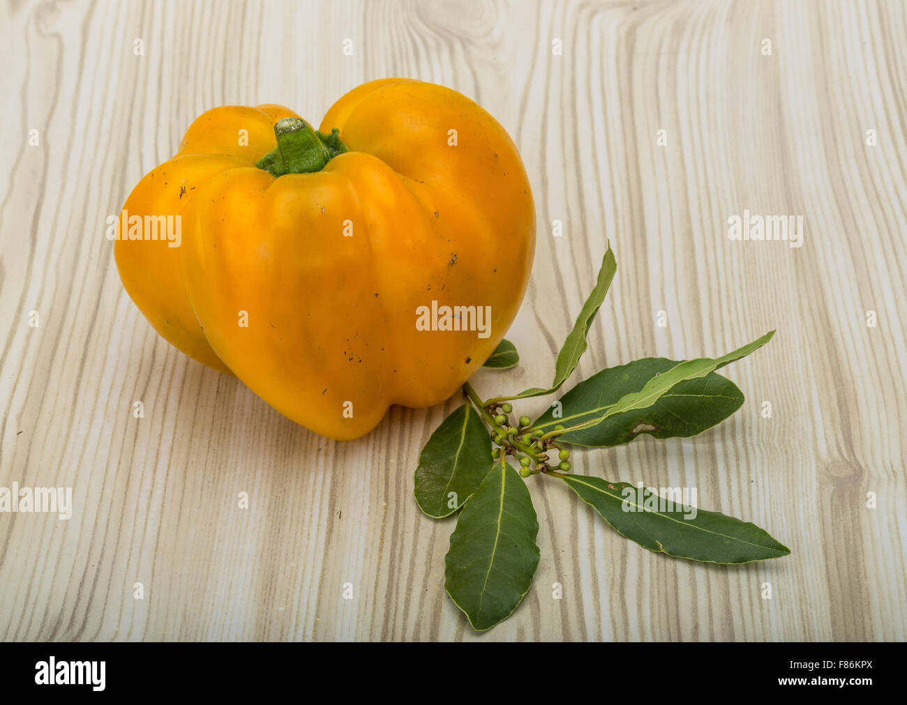 Yellow Bulgarian Pepper with laurel leaves on the wood background Stock ...