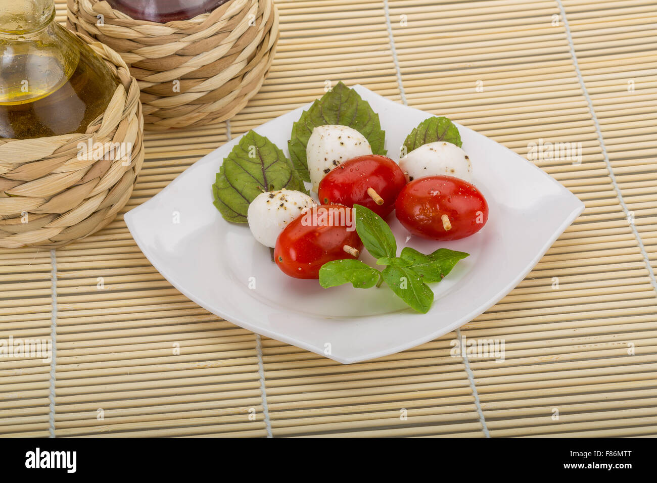 Famous italian caprese salad with fresh basil leaves Stock Photo - Alamy