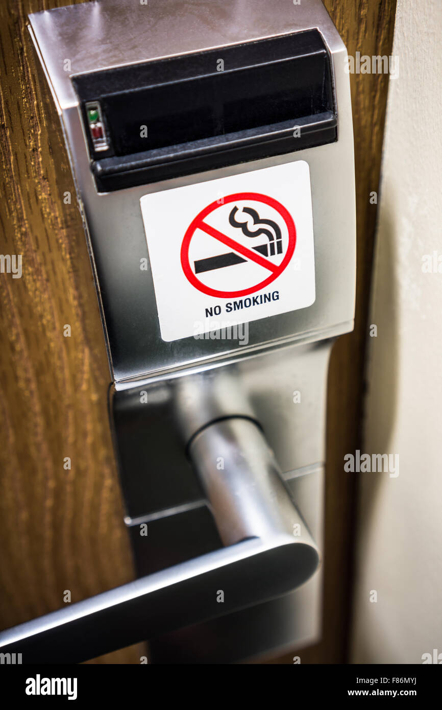 Picture of no smoking sign on a hotel room electronic door lock handle ...