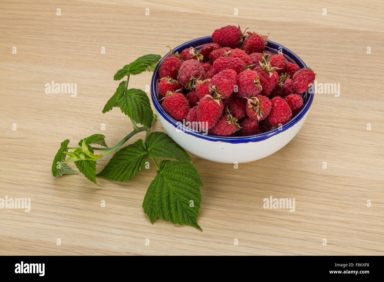 Raspberry in the bowl with leaves Stock Photo - Alamy
