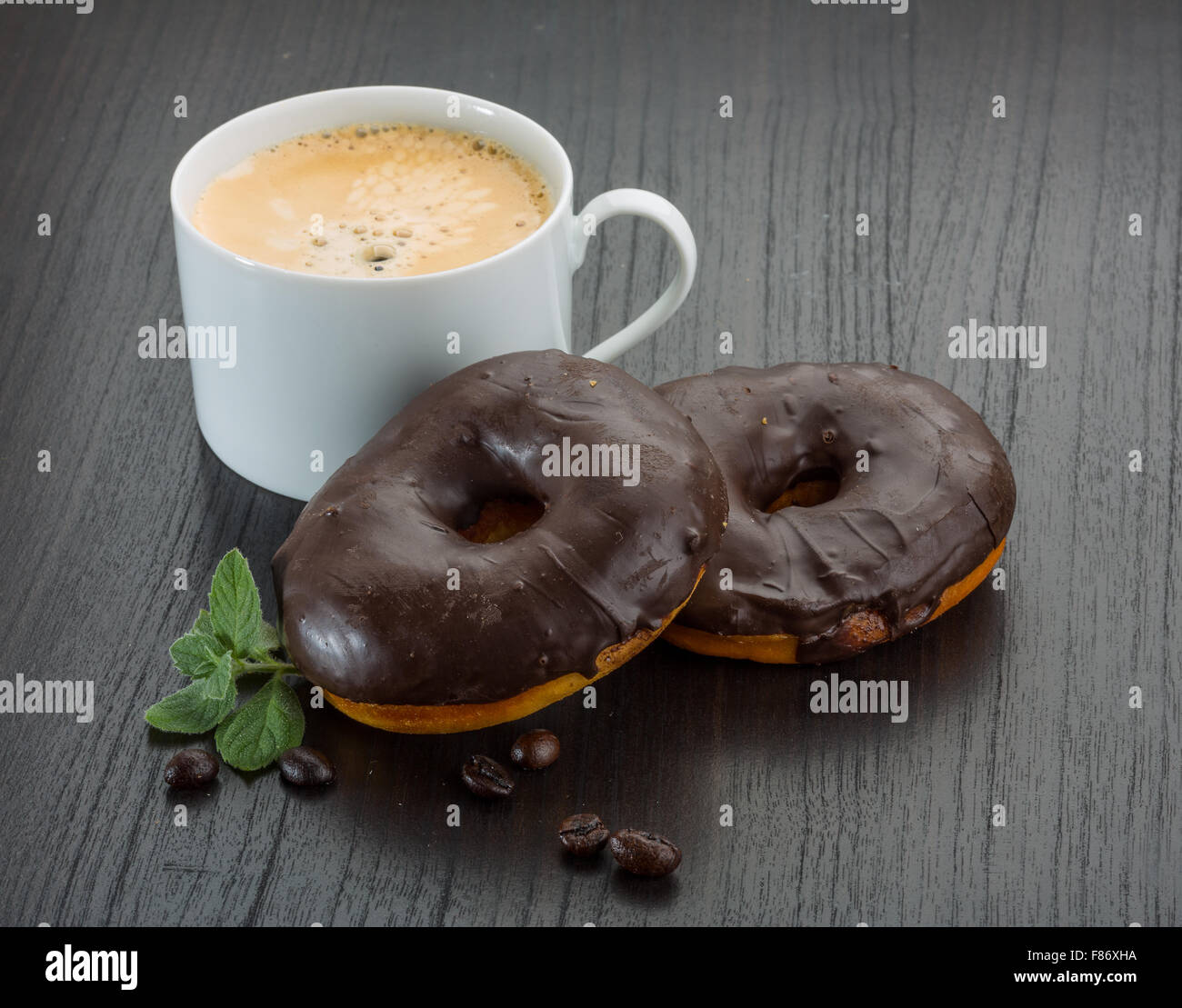 Chocolate donuts with coffee on the desk Stock Photo - Alamy