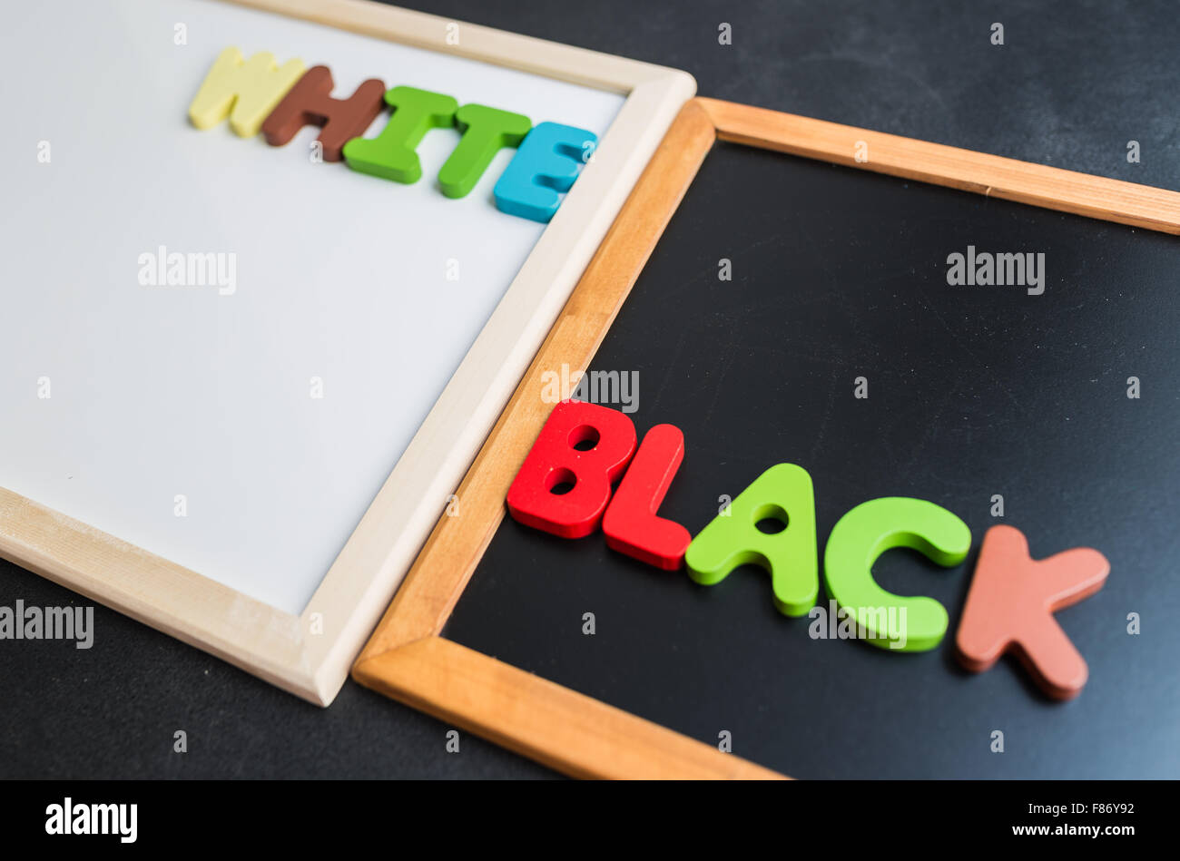 Wooden word WHITE and BLACK on black board and white board in blur ...
