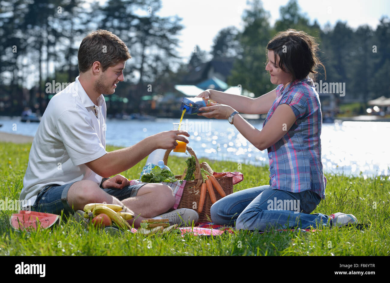 happy young romantic couple in love having a picnic outdoor on a summer ...