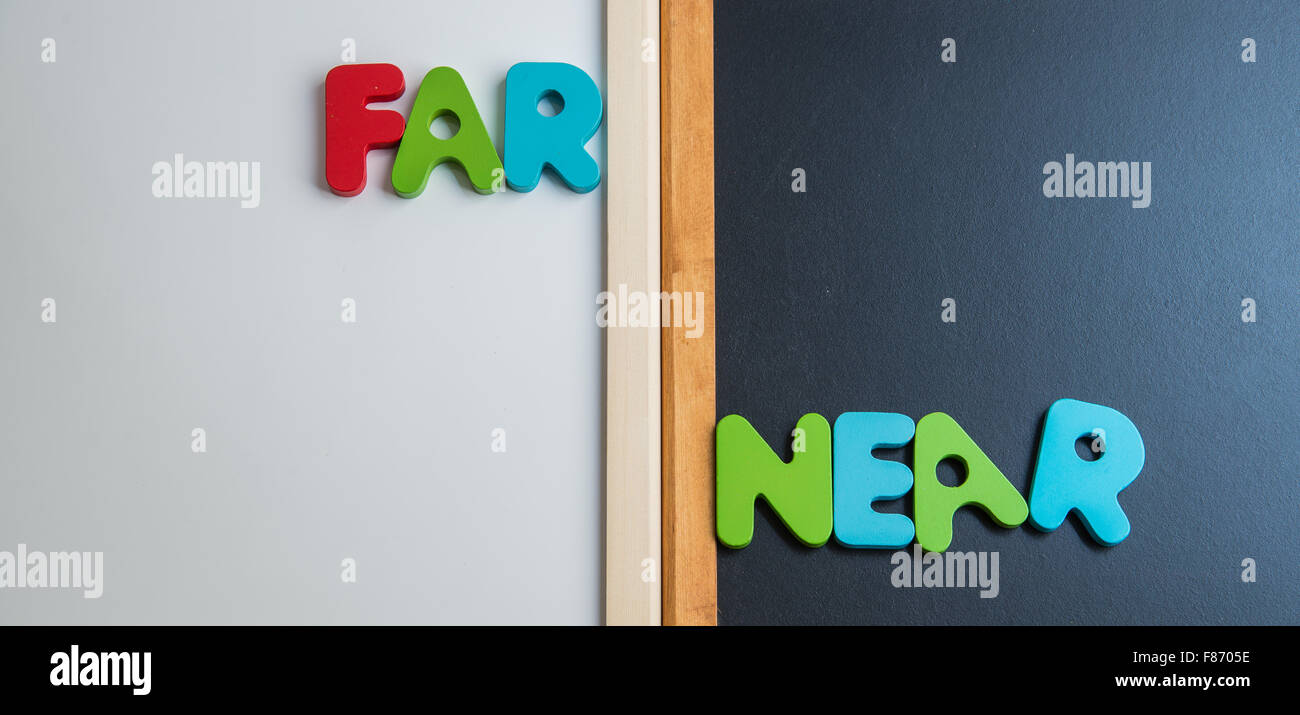 Wooden word FAR and NEAR on black board and white board Stock Photo - Alamy