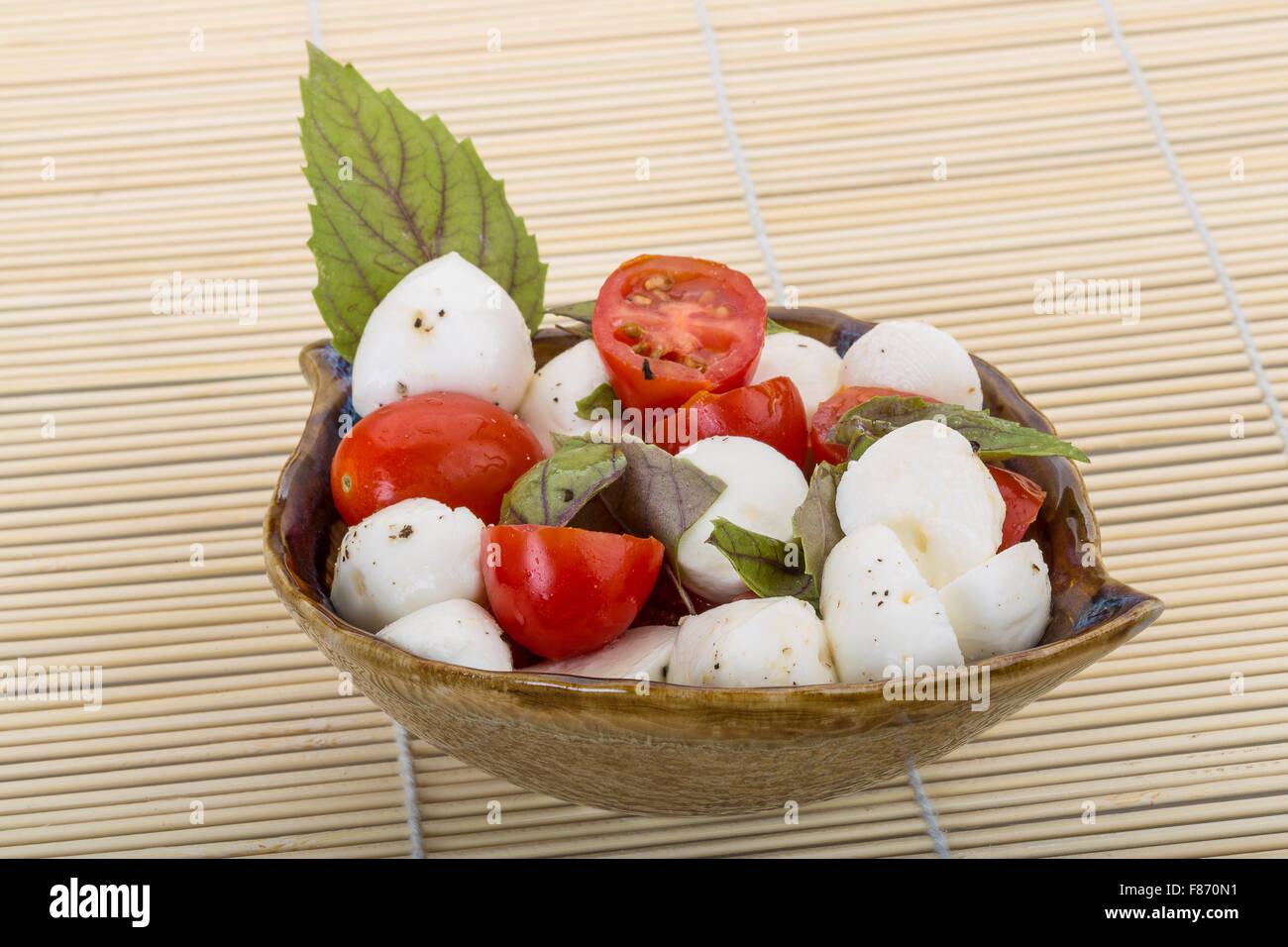 Famous italian caprese salad with fresh basil leaves Stock Photo - Alamy