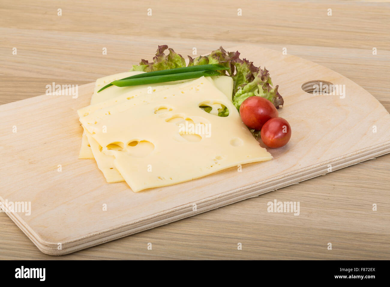 Maasdam cheese slices on the wooden background Stock Photo - Alamy