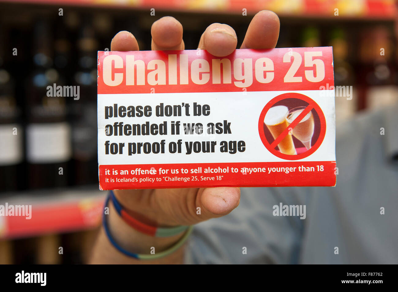 A man holds a Challenge 25 card up to check the age with proof of ...