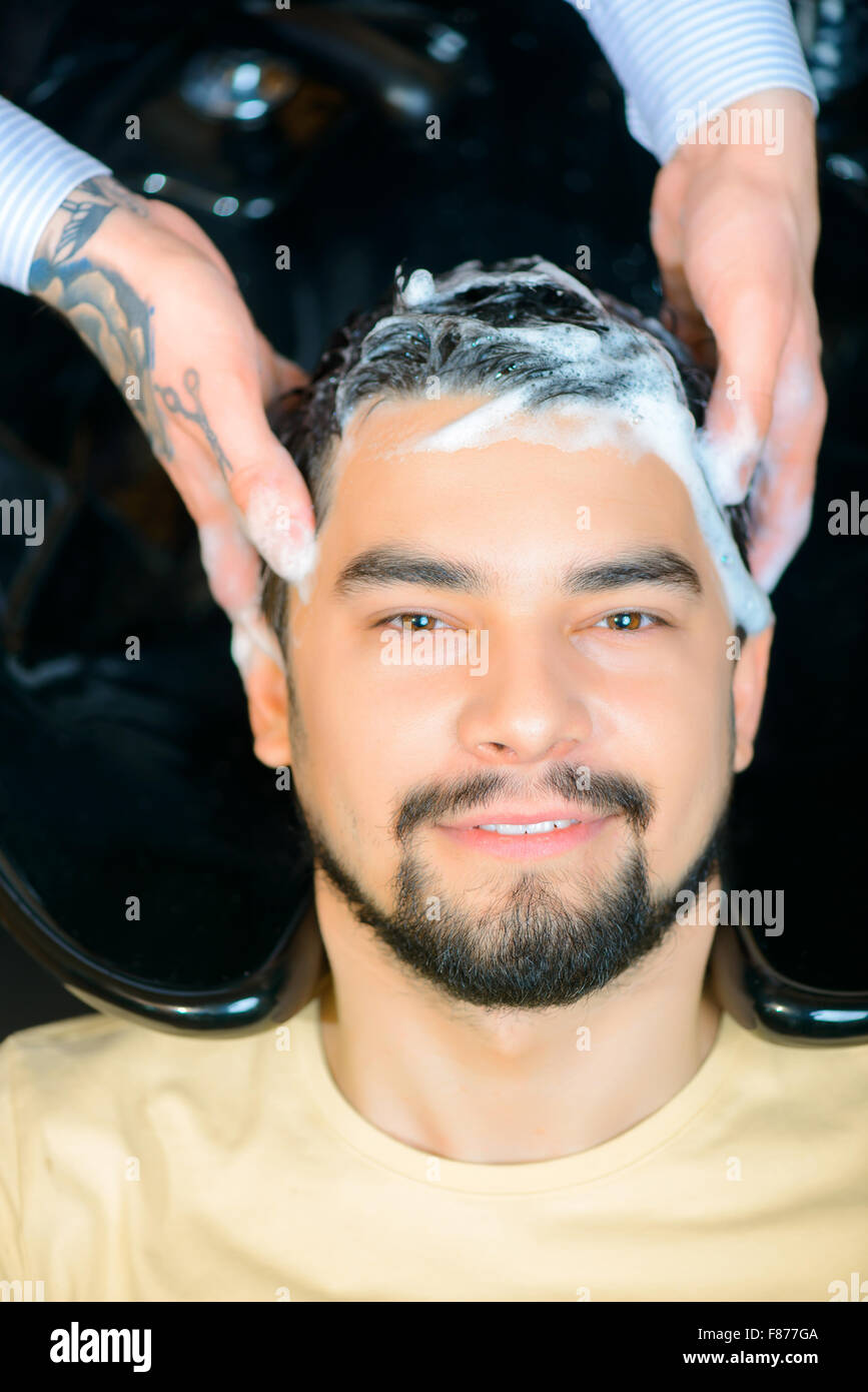 Professional barber washing hair of the client Stock Photo - Alamy