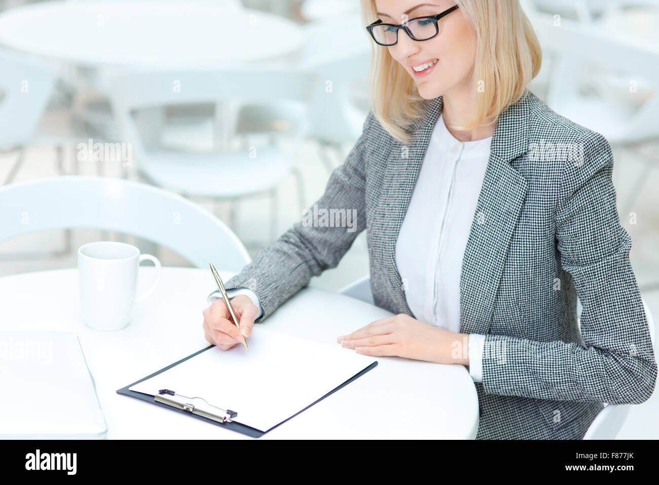 Pretty business woman signing papers Stock Photo - Alamy