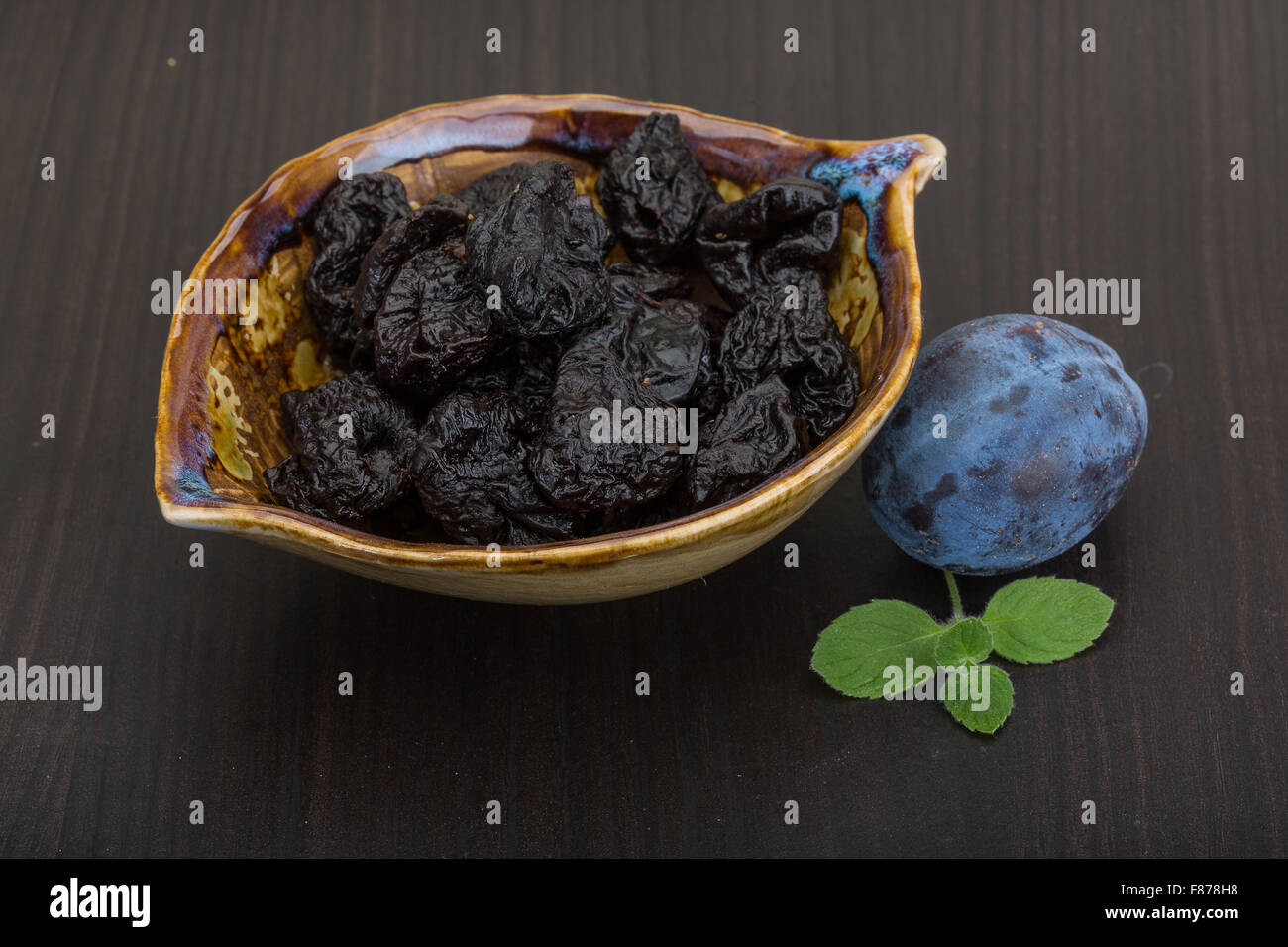Dried plums in the bowl with fresh prune Stock Photo - Alamy