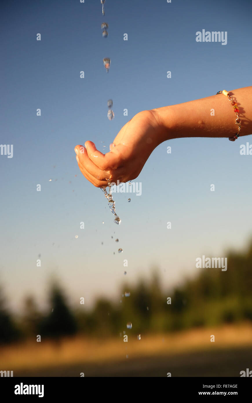 clear water falling on children hands Stock Photo - Alamy