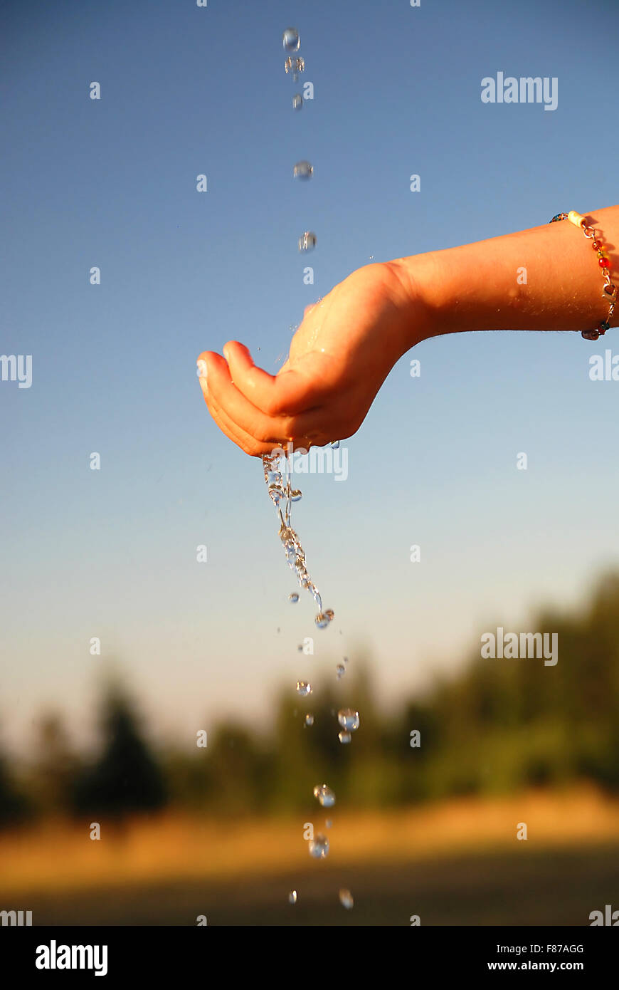 clear water falling on children hands Stock Photo - Alamy