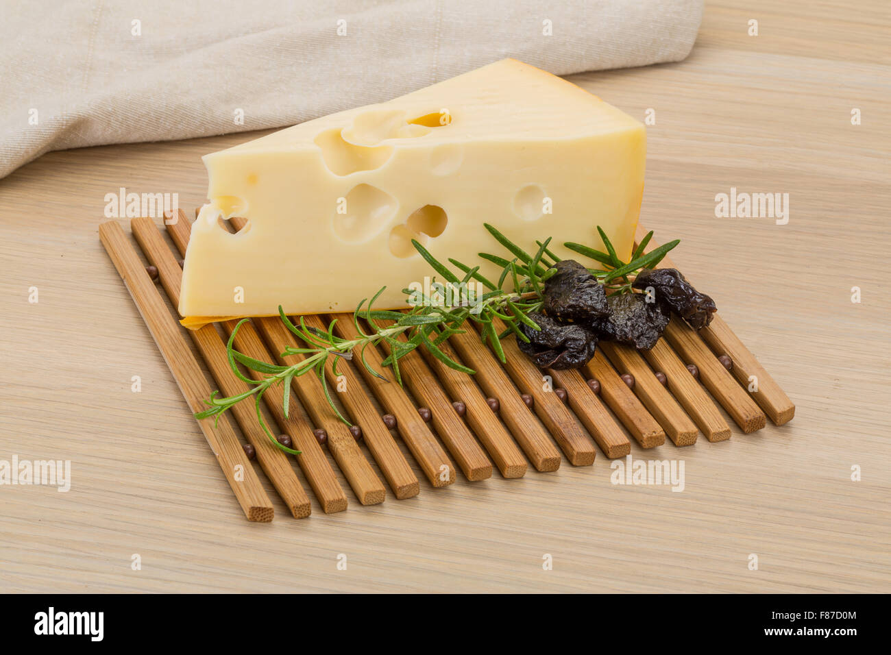 Yellow Cheese maasdam - on the board with herbs Stock Photo - Alamy