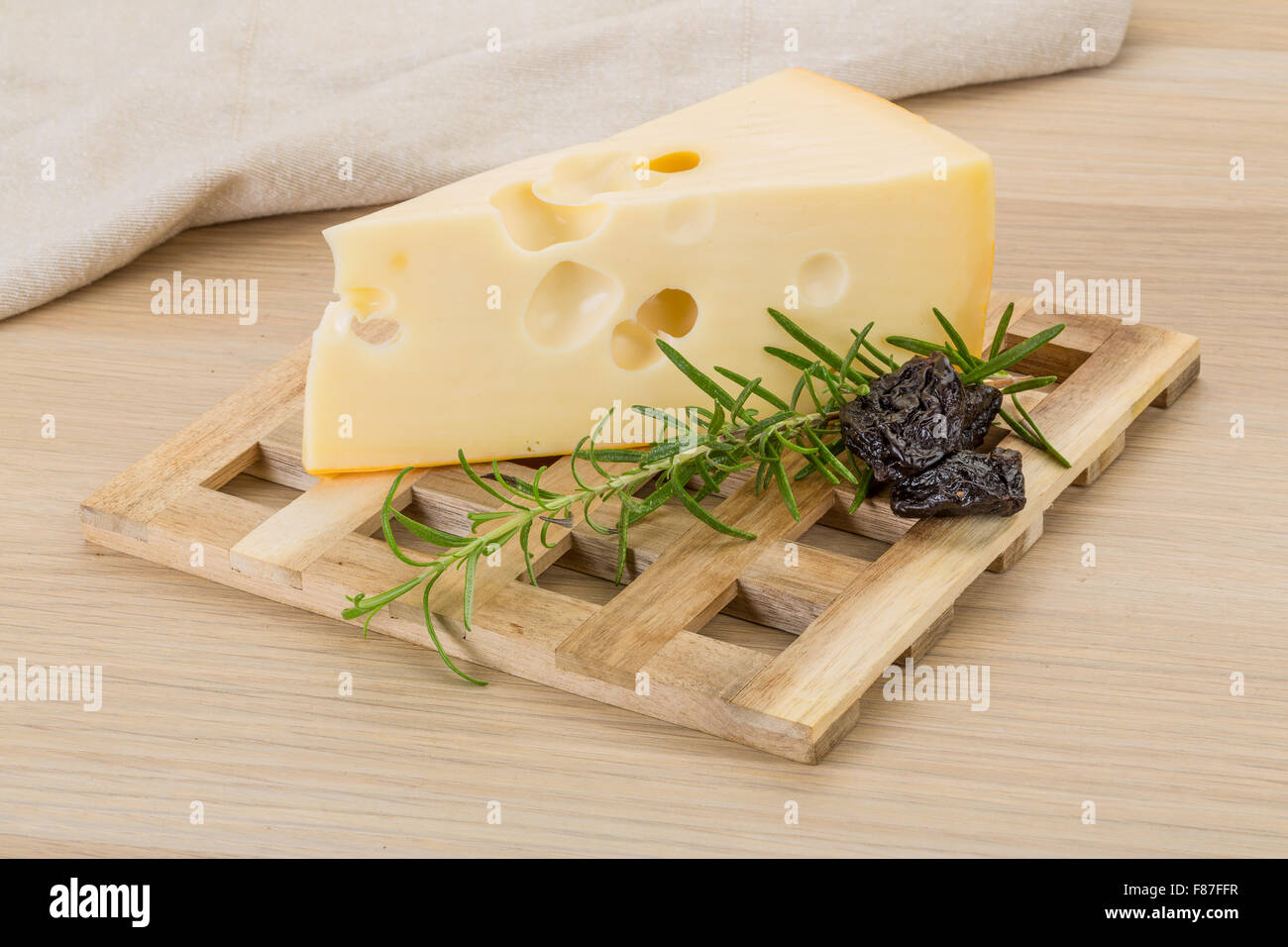 Yellow Cheese maasdam - on the board with herbs Stock Photo - Alamy