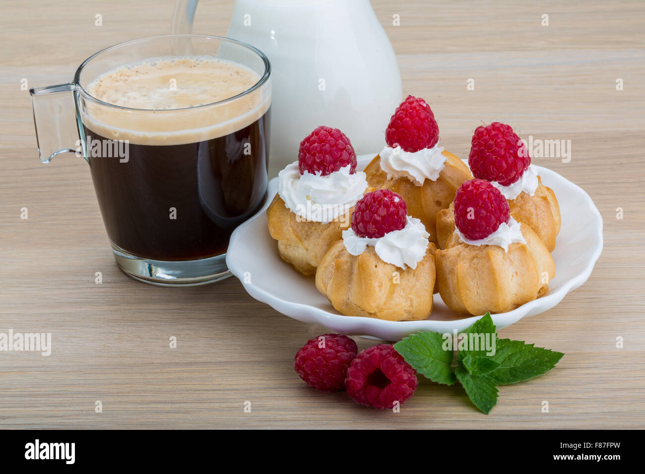 Profiterole with raspberry and cup of coffee Stock Photo - Alamy