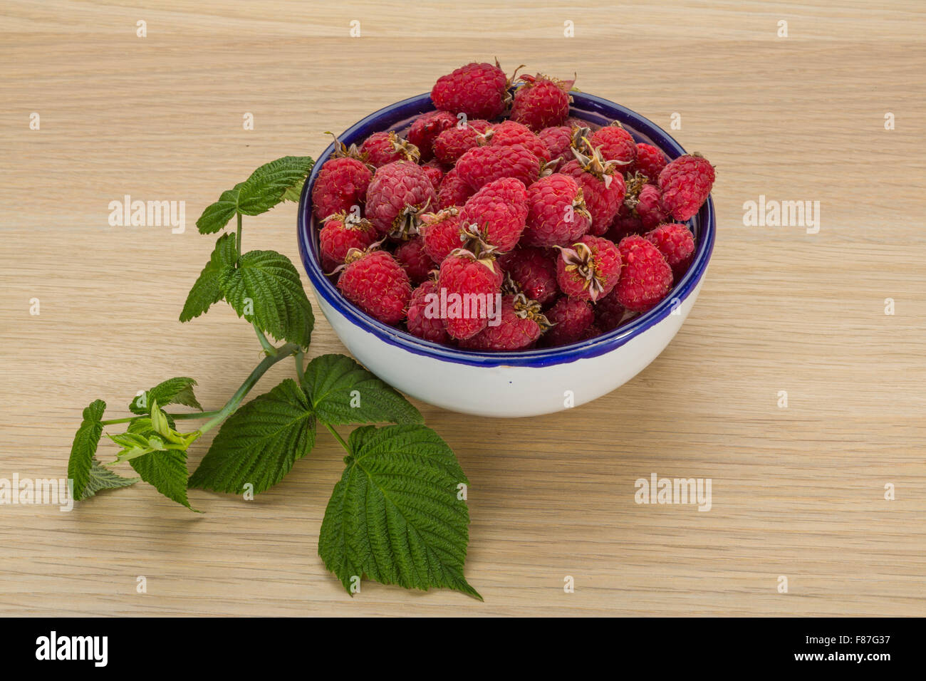Raspberry in the bowl with leaves Stock Photo - Alamy