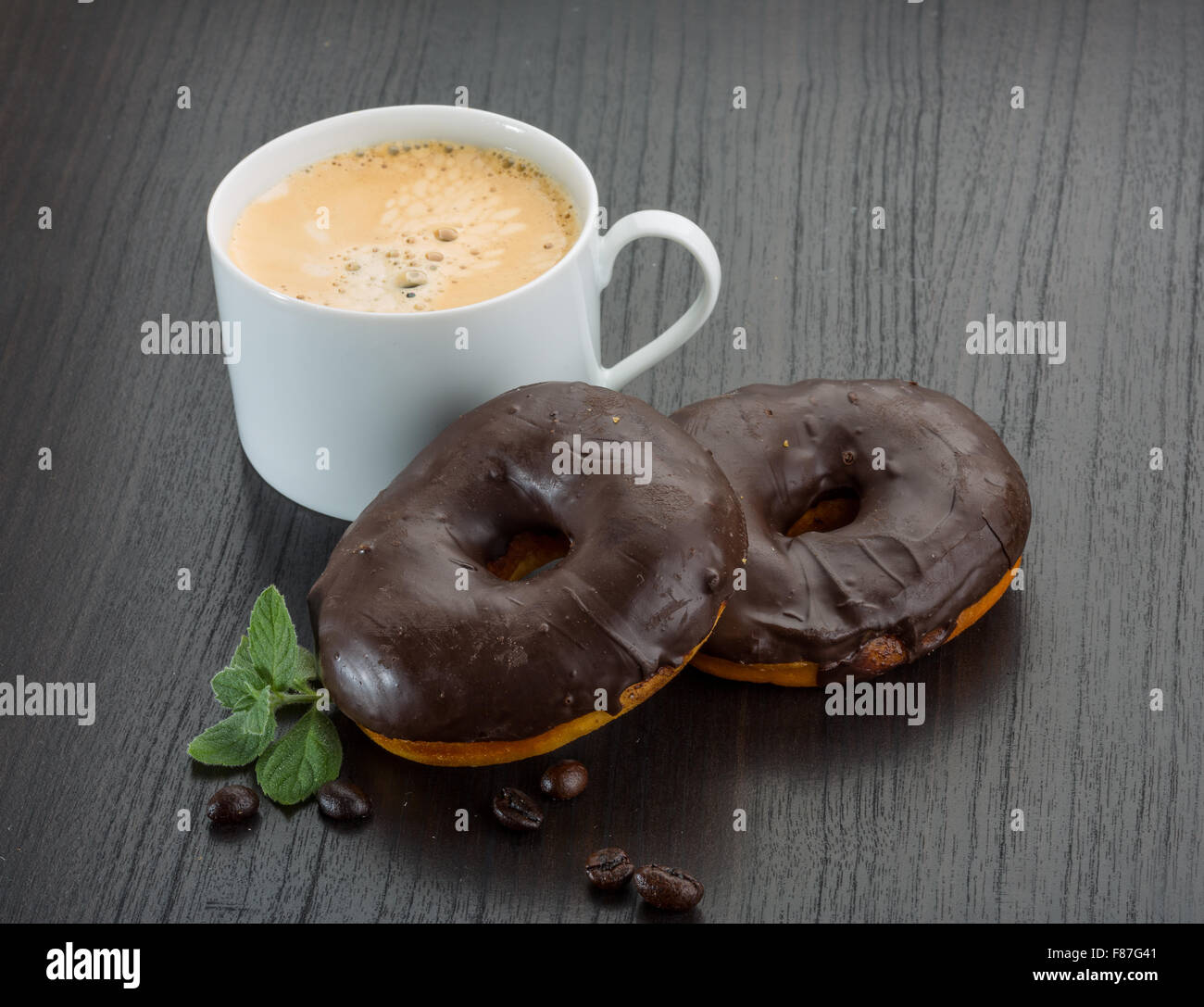 Chocolate donuts with coffee on the desk Stock Photo - Alamy