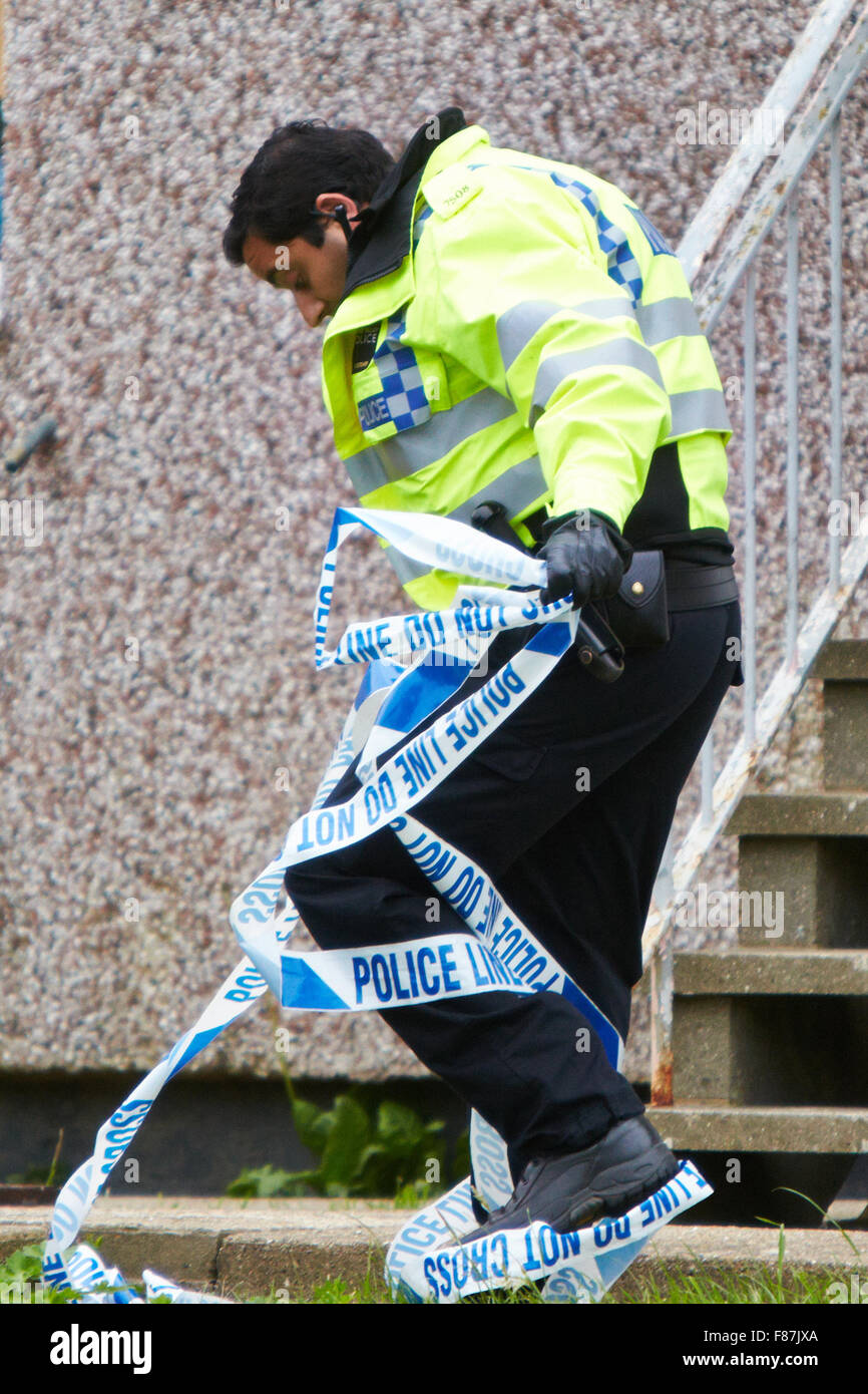 A police officer struggles with tape at a crime scene Stock Photo - Alamy