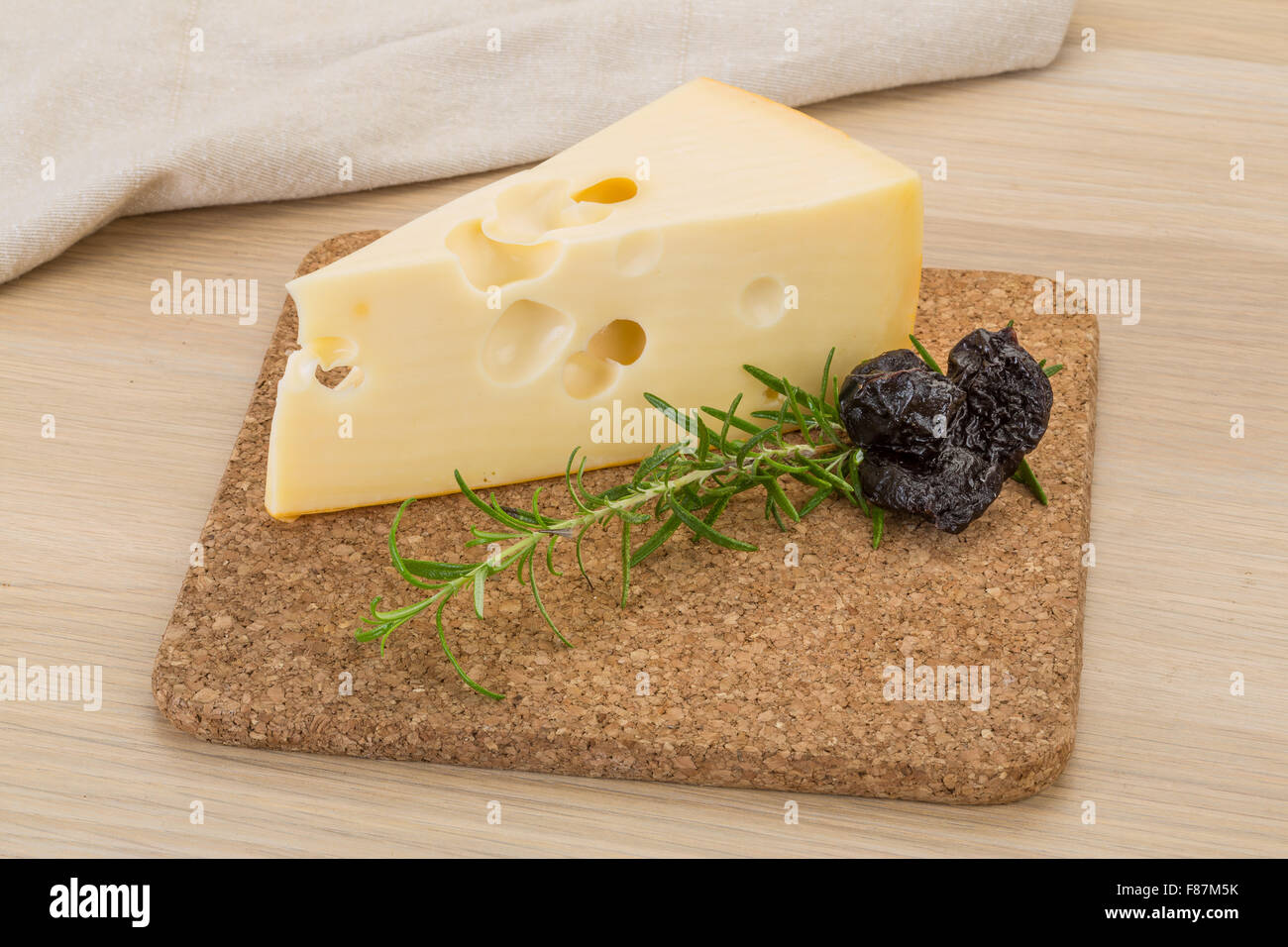 Yellow Cheese maasdam - on the board with herbs Stock Photo - Alamy