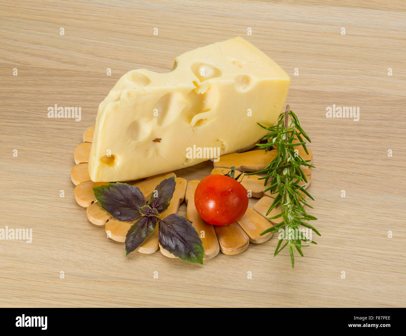 Maasdam cheese on the board with rosemary and mint Stock Photo - Alamy