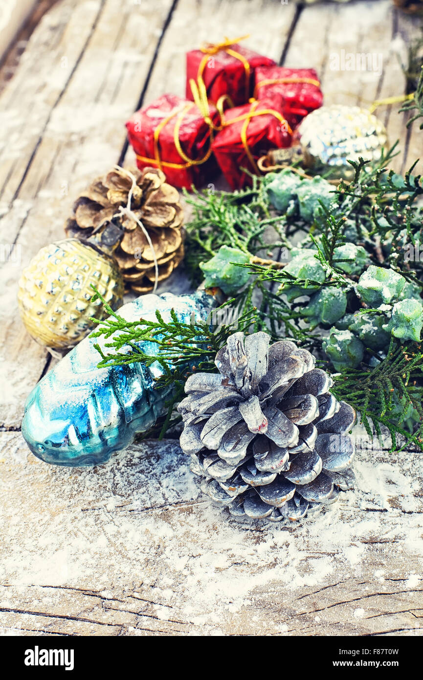 Branch of thuja,pine cones and Christmas toys on wooden snowy ...