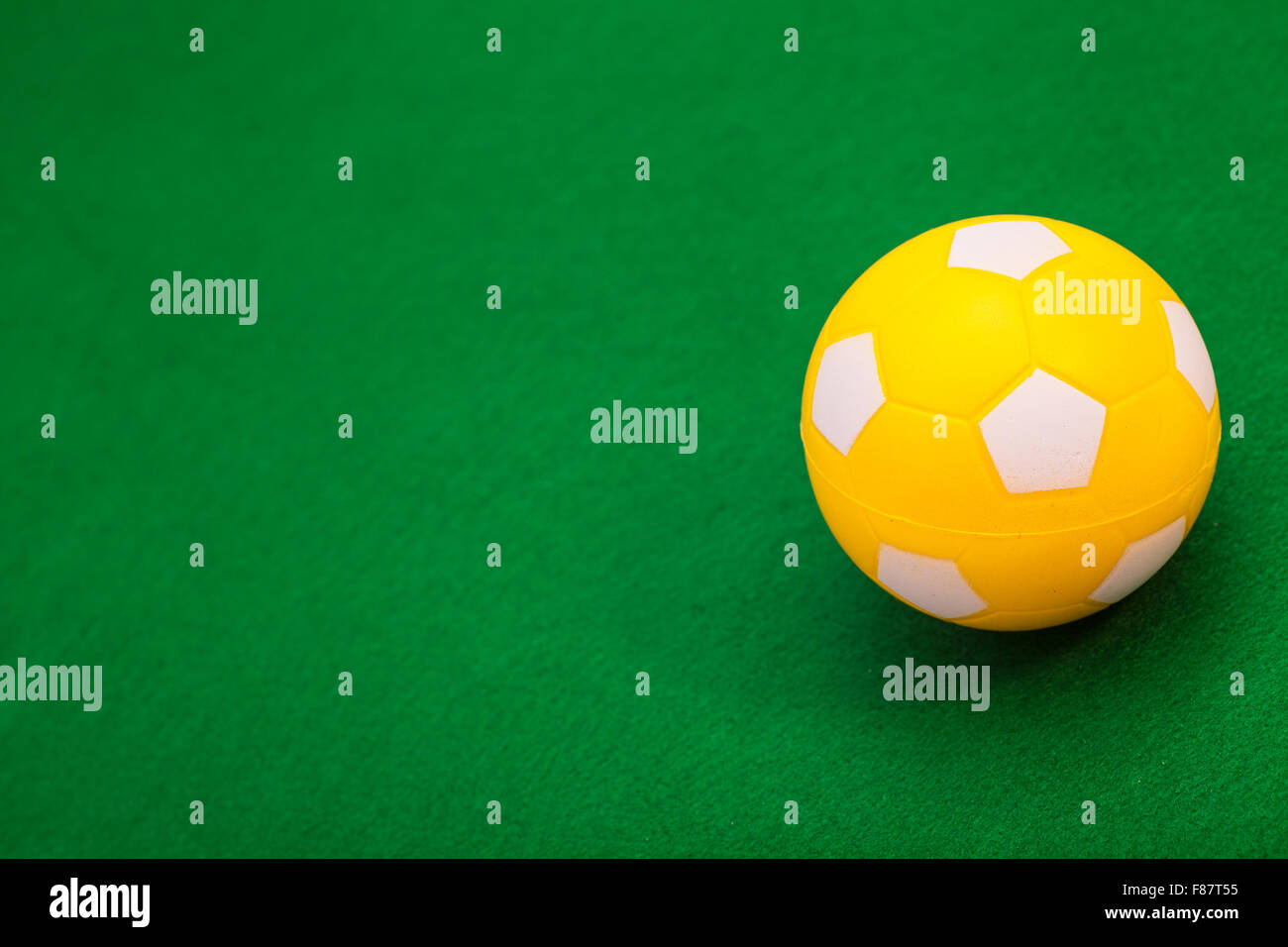 Yellow Soccer ball on green field Stock Photo - Alamy