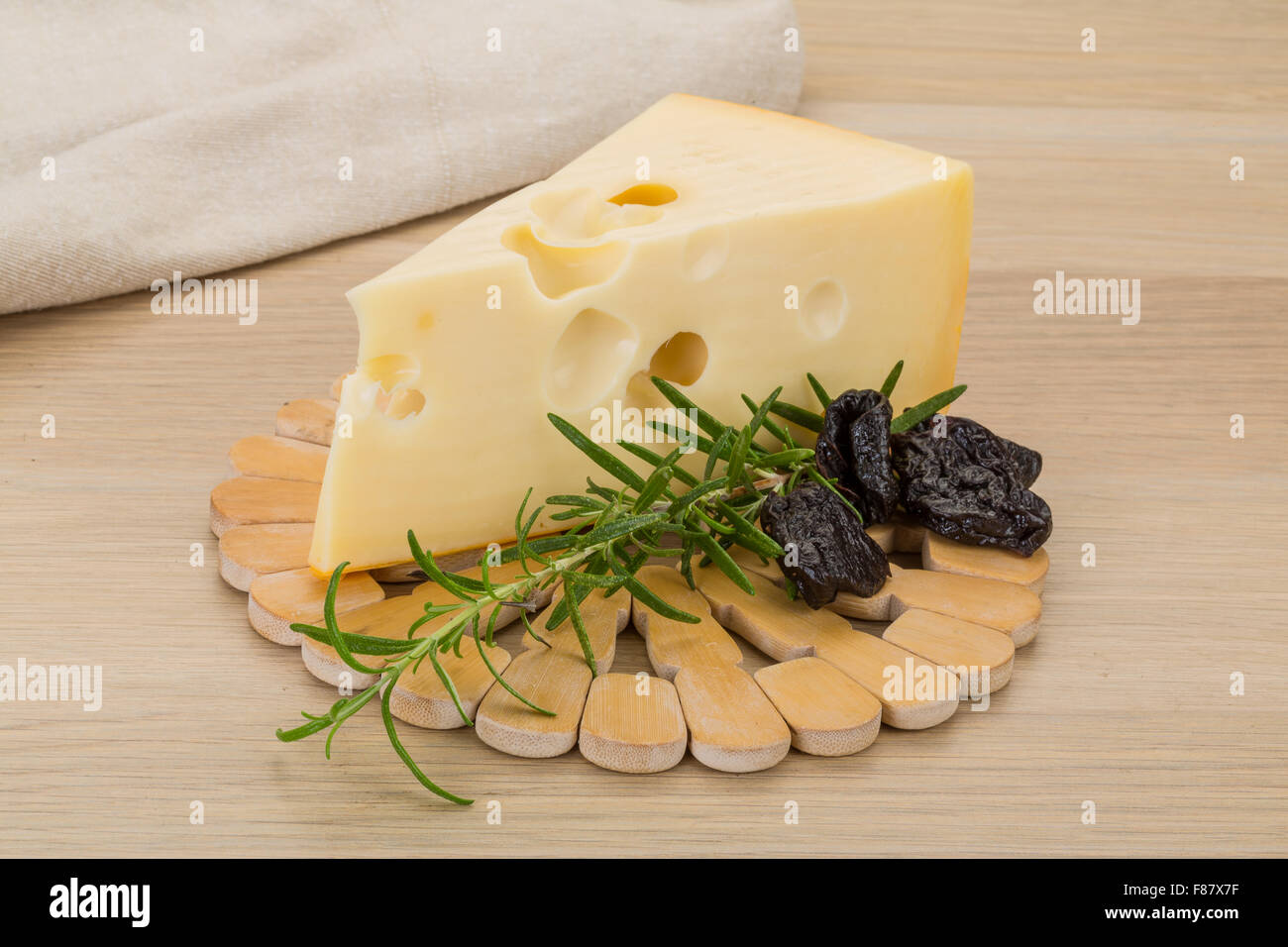 Yellow Cheese maasdam - on the board with herbs Stock Photo - Alamy