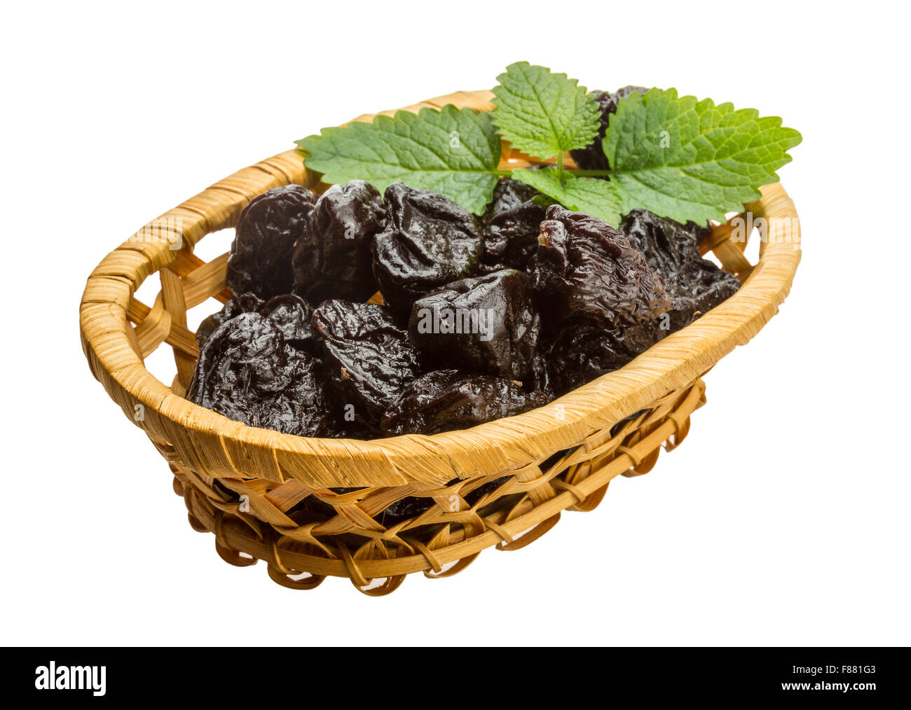 Dried plums with melissa leaves isolated on white Stock Photo - Alamy