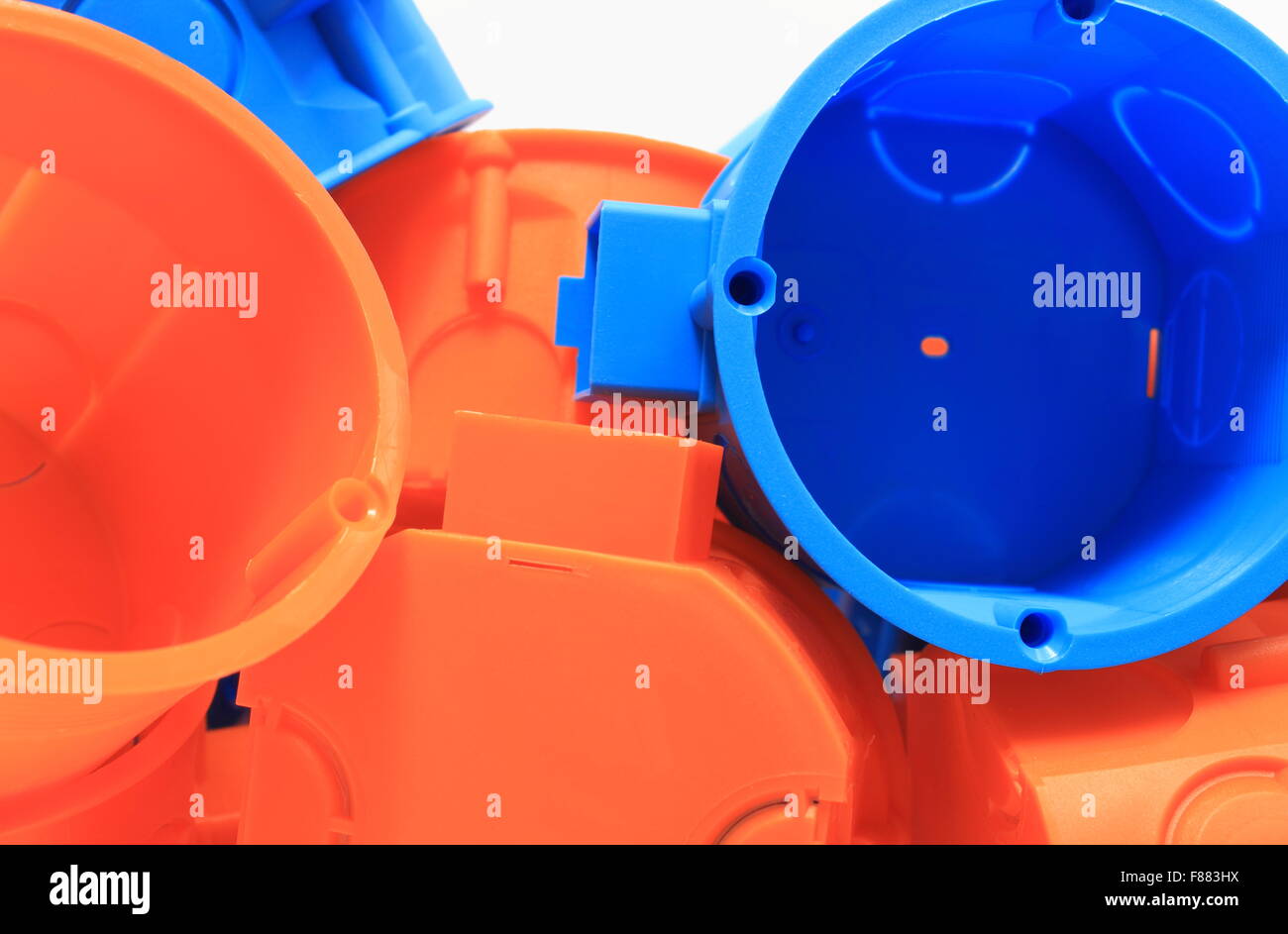 Heap of blue and orange plastic electrical boxes, components for ...
