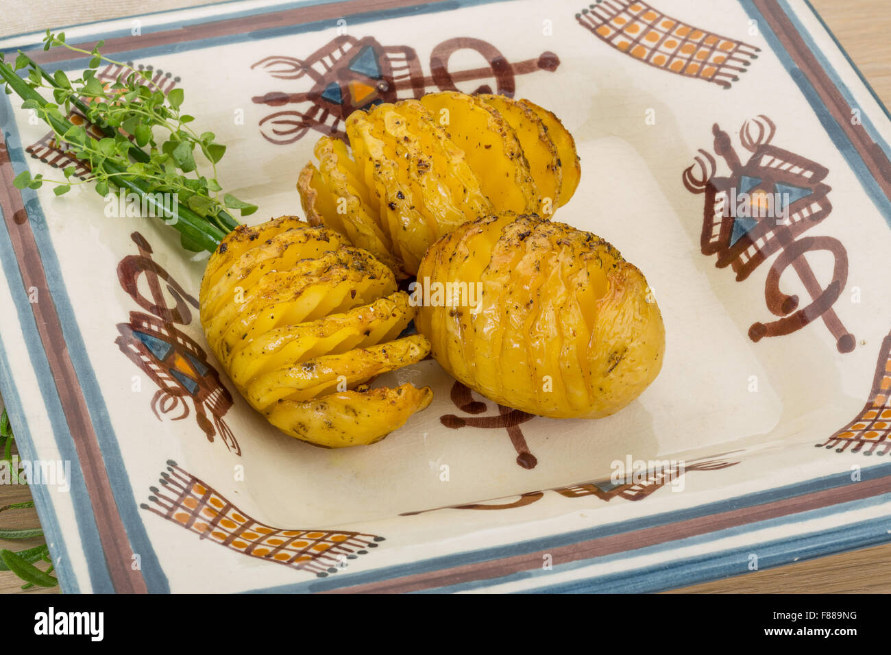 Baked potao with oregano on the desk Stock Photo - Alamy