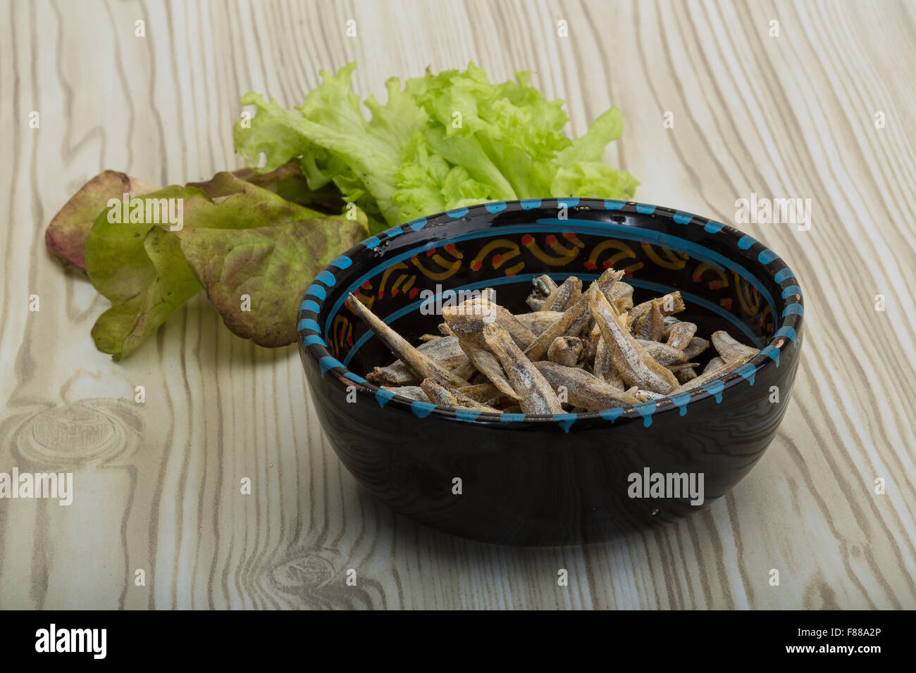 Dries anchovy - small fishes in the bowl Stock Photo - Alamy