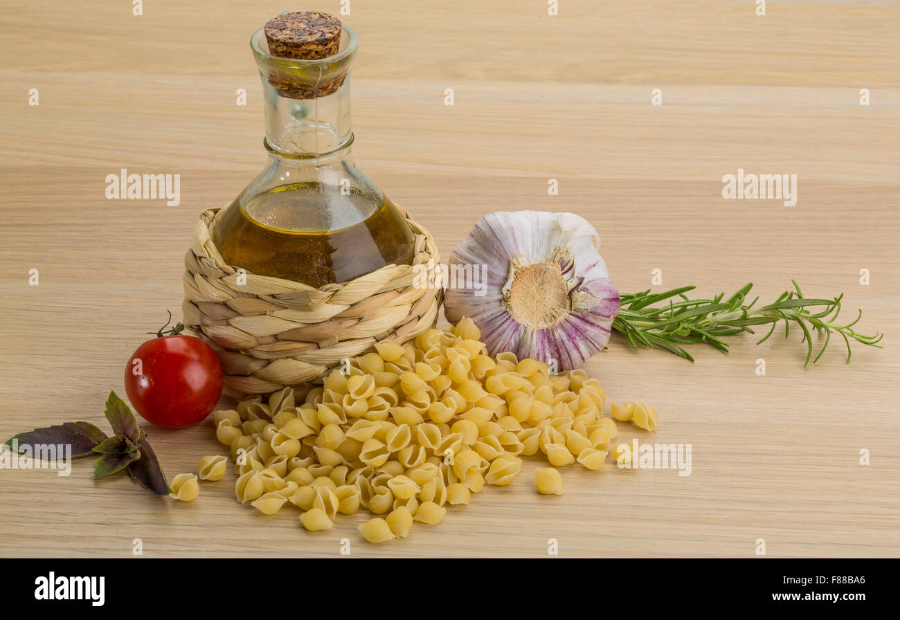 Raw macaroni - shell pasta with herbs Stock Photo - Alamy