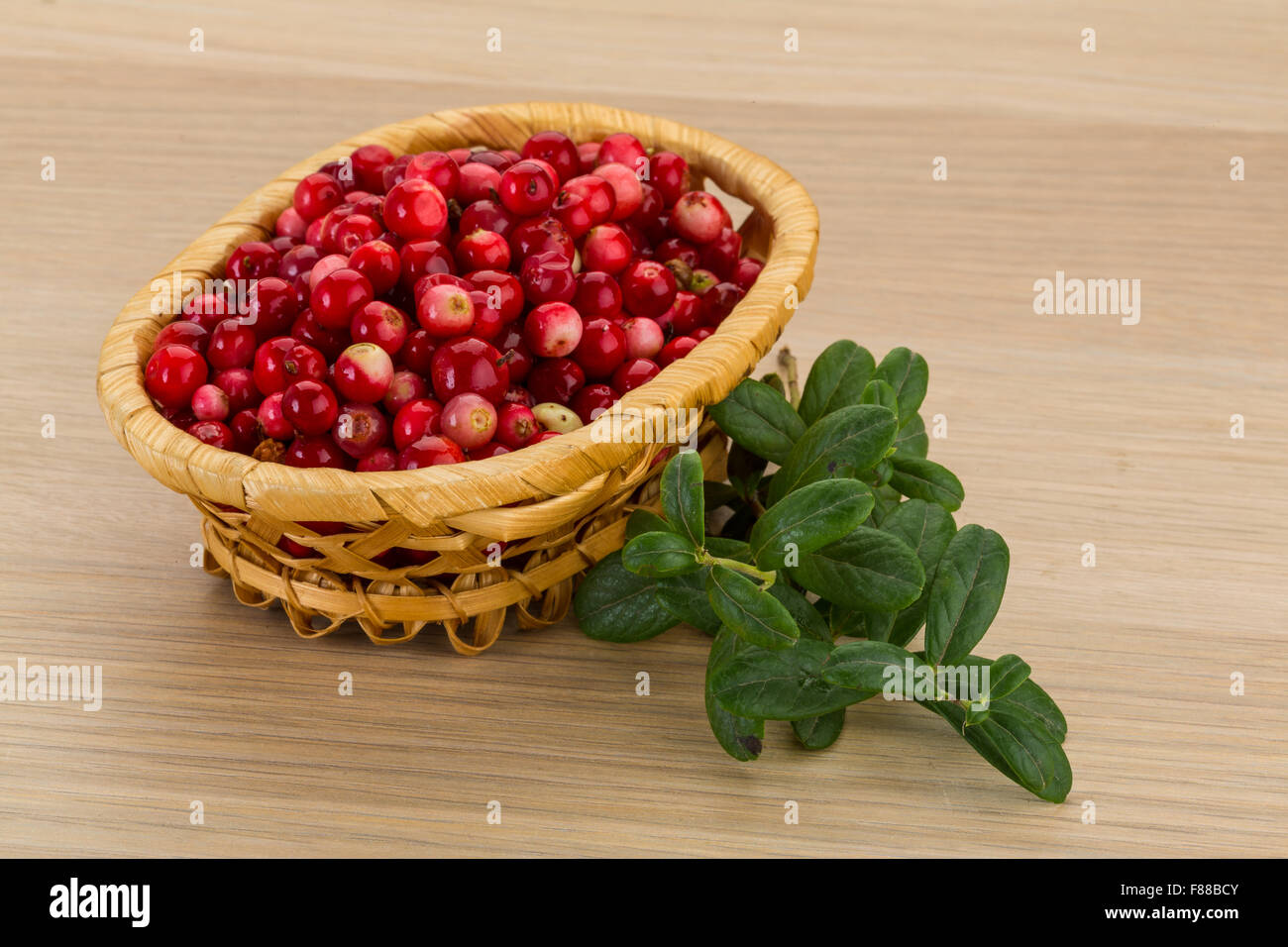 Cowberry in the bowl with leaves Stock Photo - Alamy