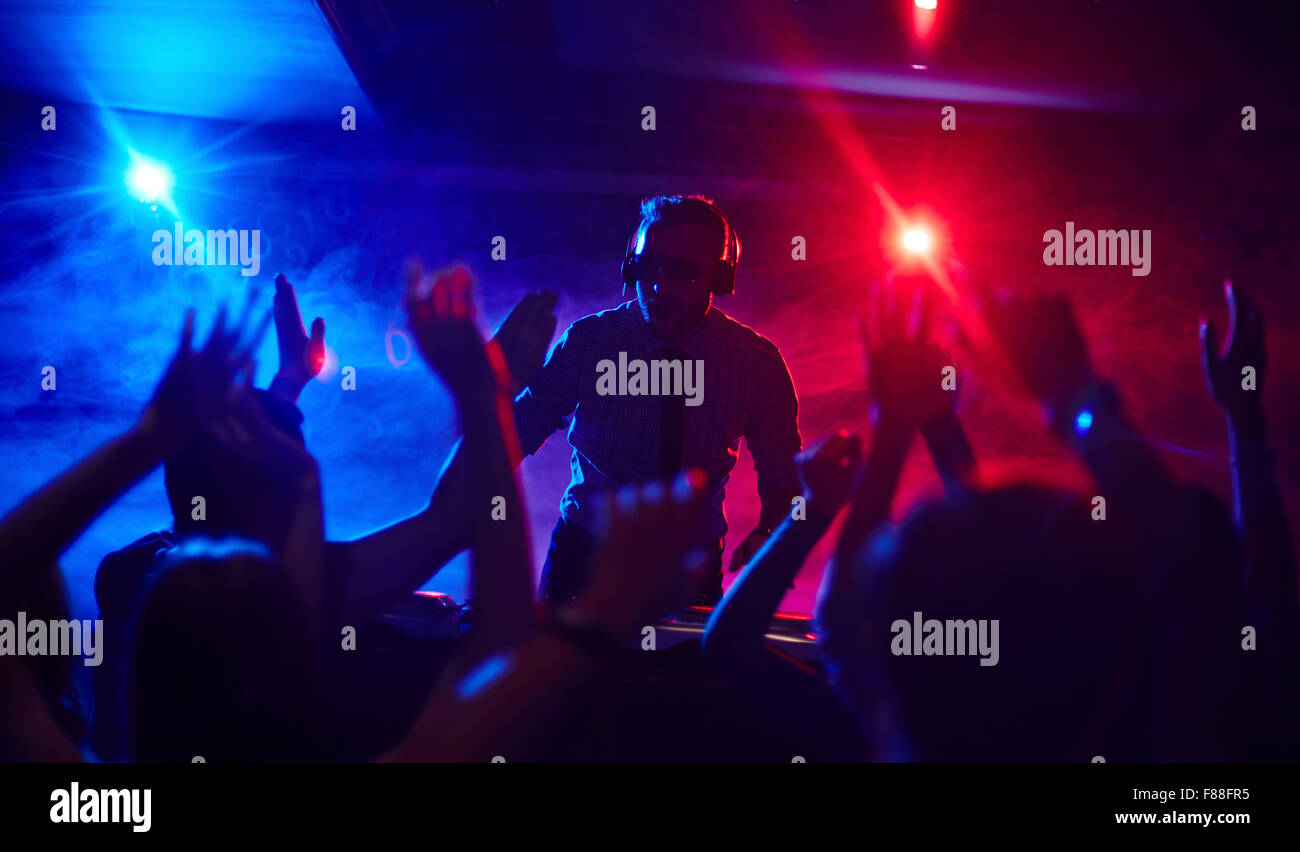 Modern deejay firing up dancing crowd in night club Stock Photo - Alamy