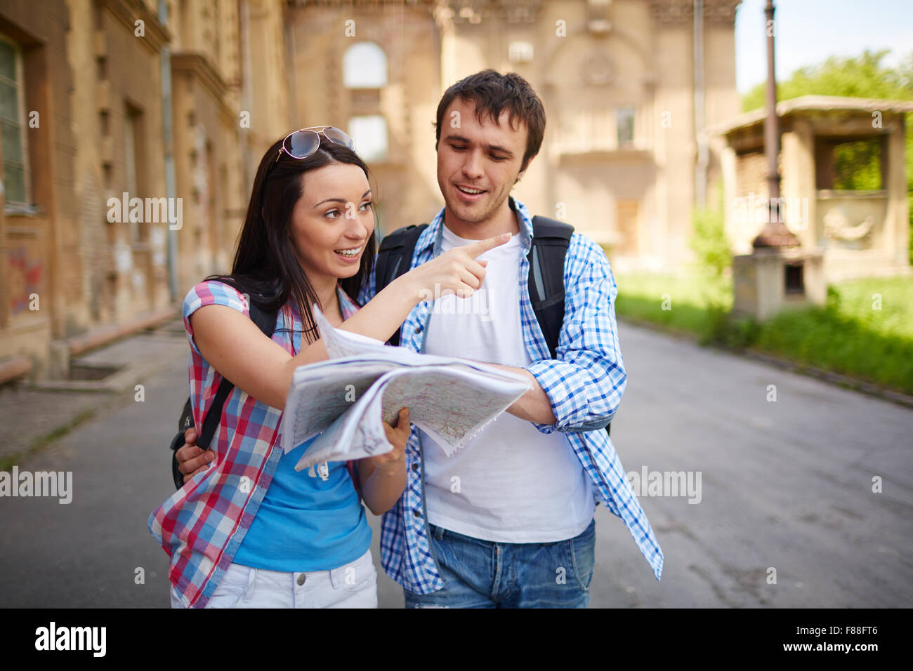 Couple of tourists consulting a city guide searching locations in the ...