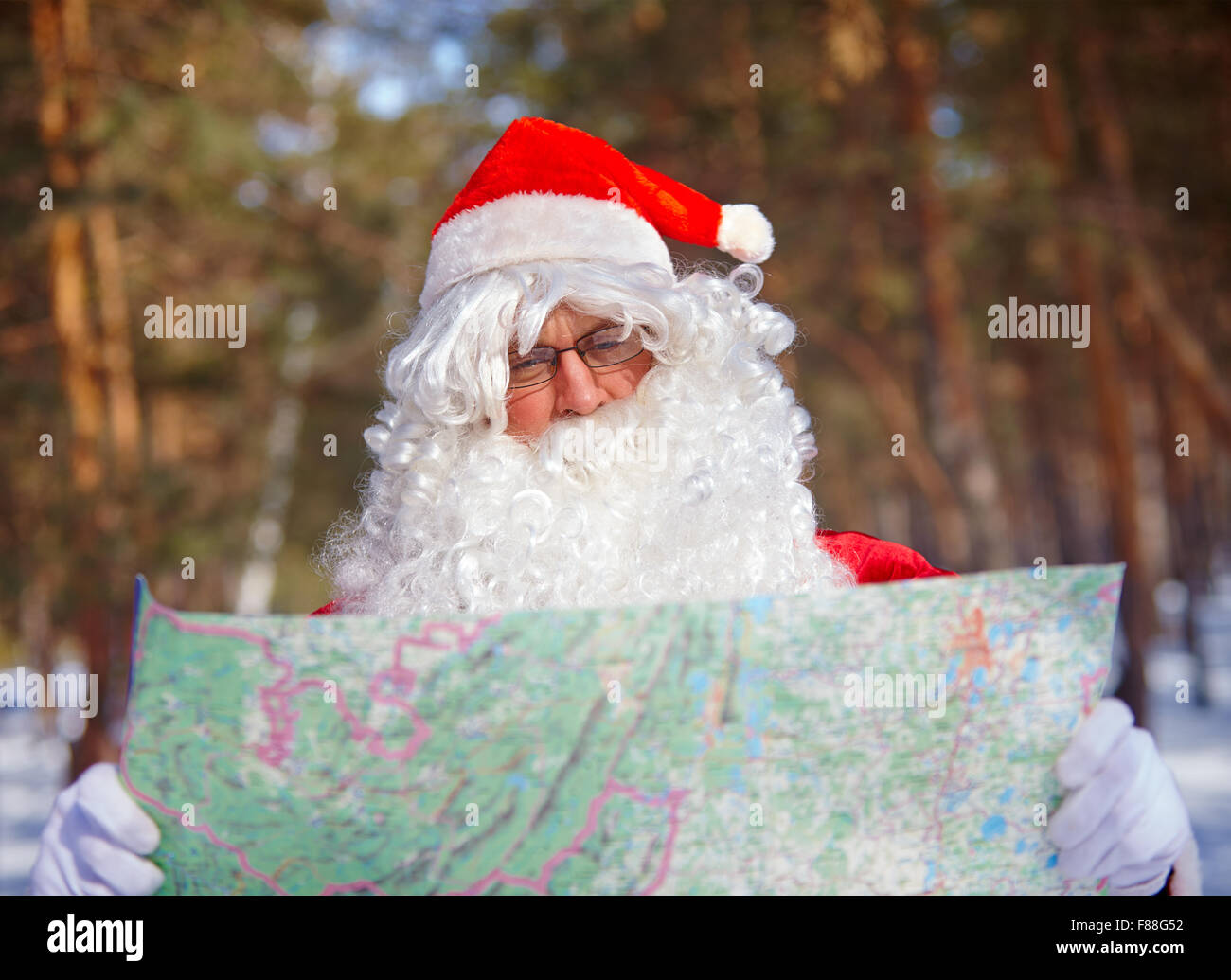 Santa Claus looking at map outdoors Stock Photo - Alamy