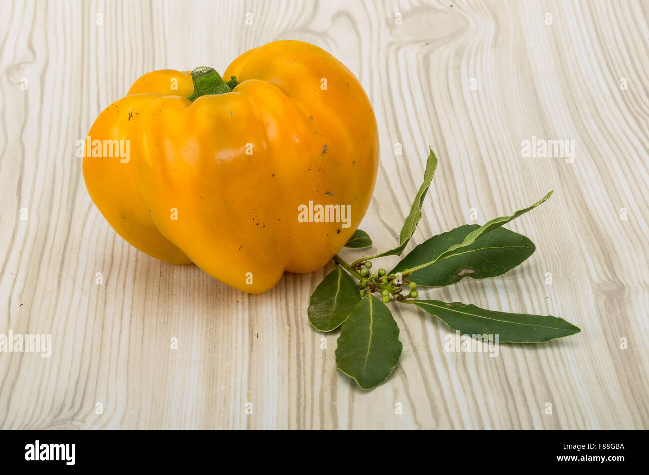 Yellow Bulgarian Pepper with laurel leaves on the wood background Stock ...