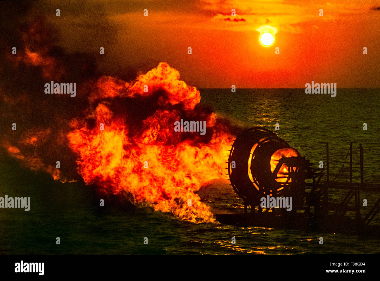 Gas burning flare on offshore oil rig at sunset, Indonesia South East ...