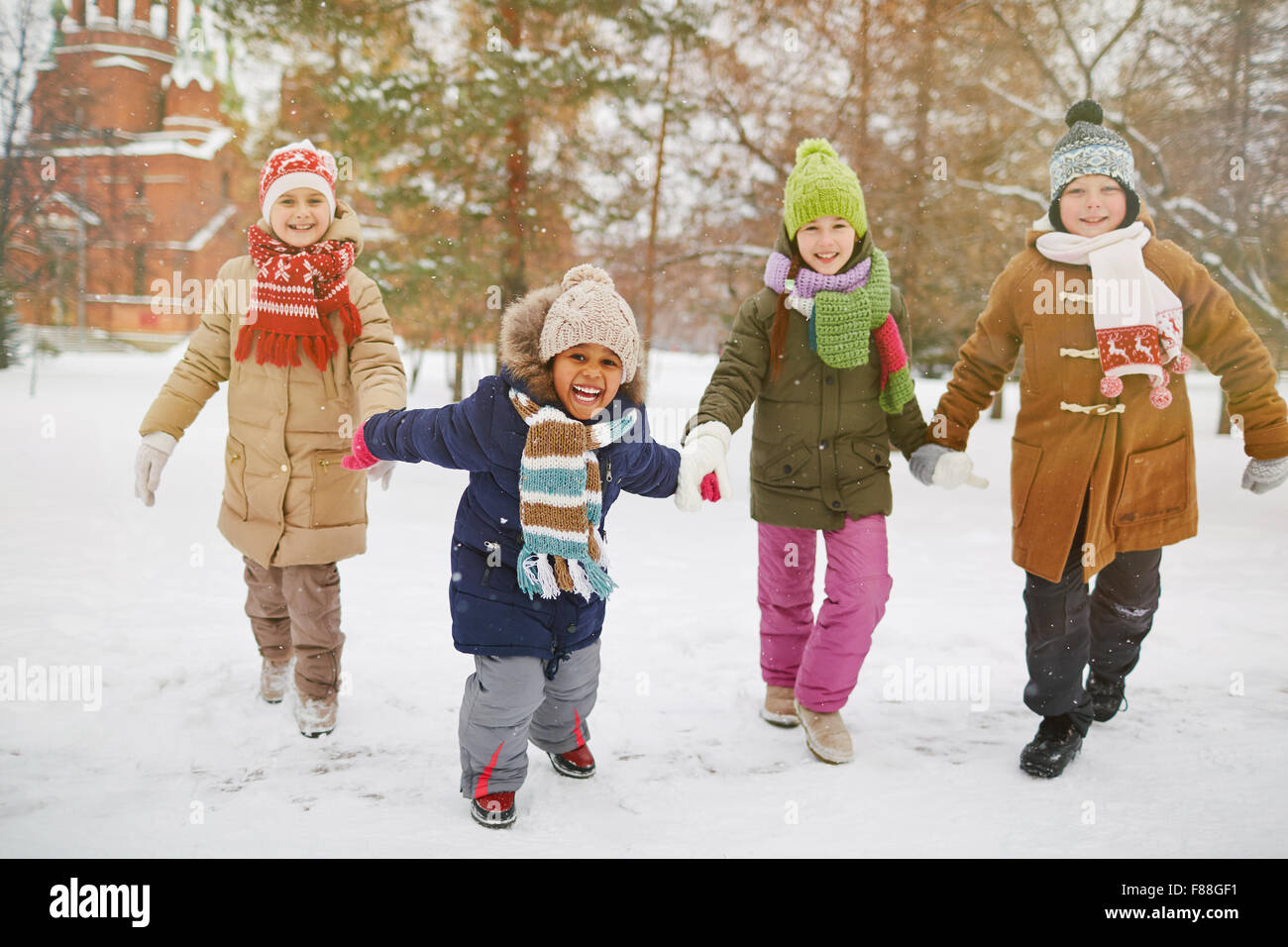 Cheerful kids running in snow in park Stock Photo - Alamy