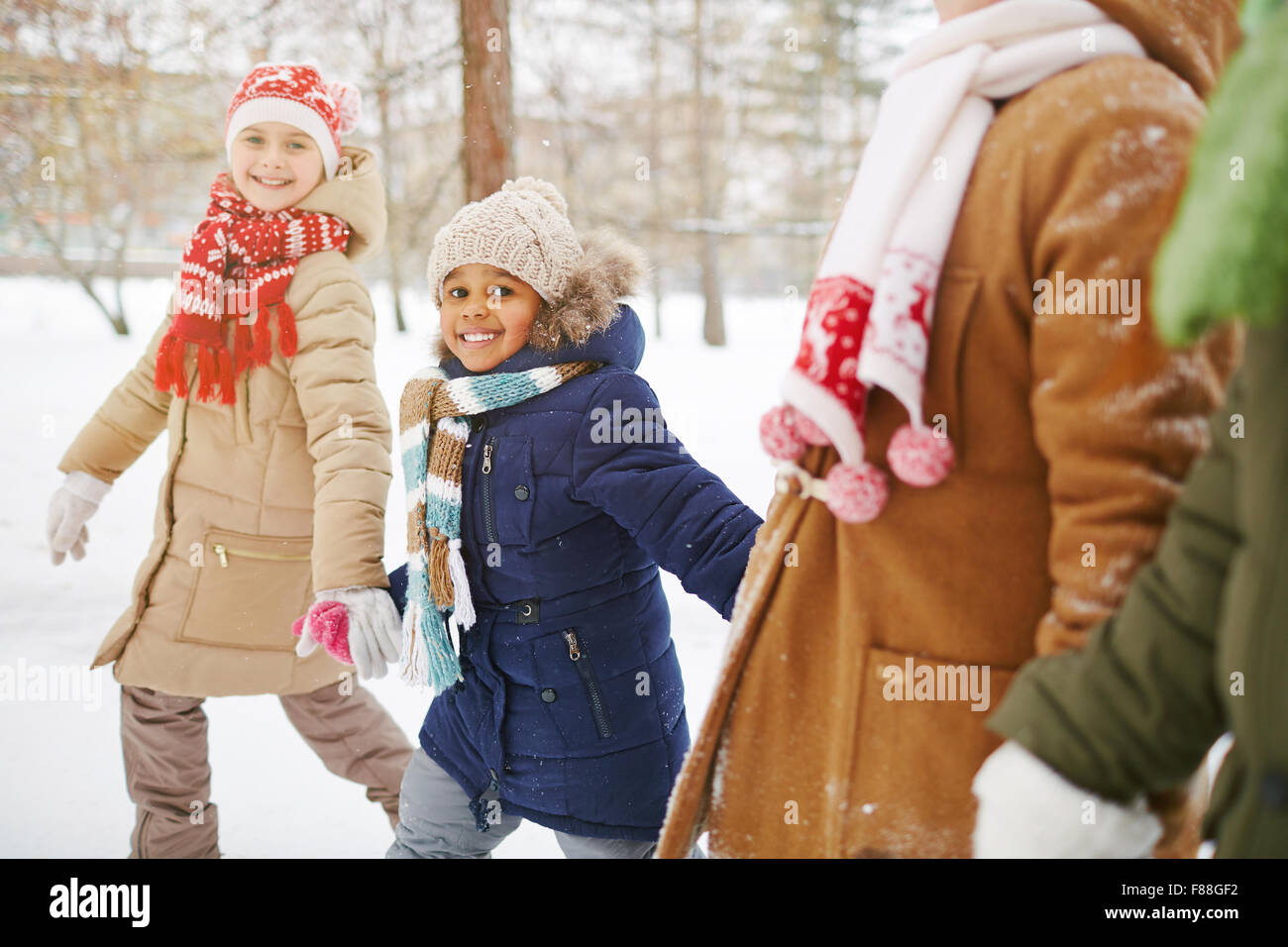 Happy kids taking walk in winter park Stock Photo - Alamy