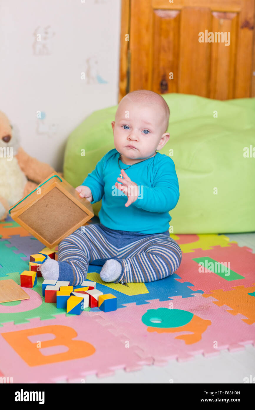 Cute little baby playing with colorful toys Stock Photo - Alamy