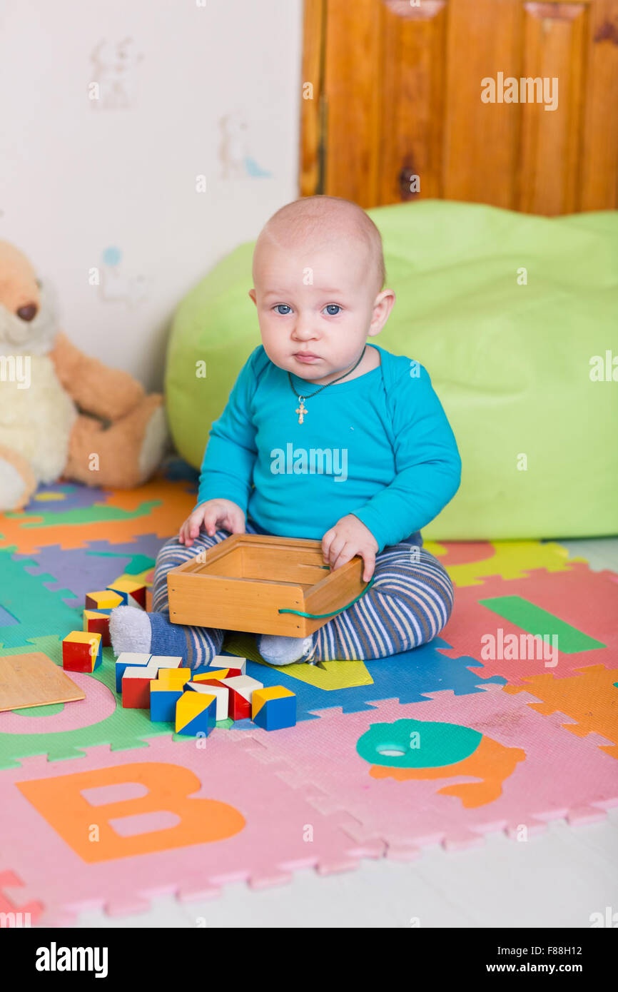 Cute little baby playing with colorful toys Stock Photo - Alamy