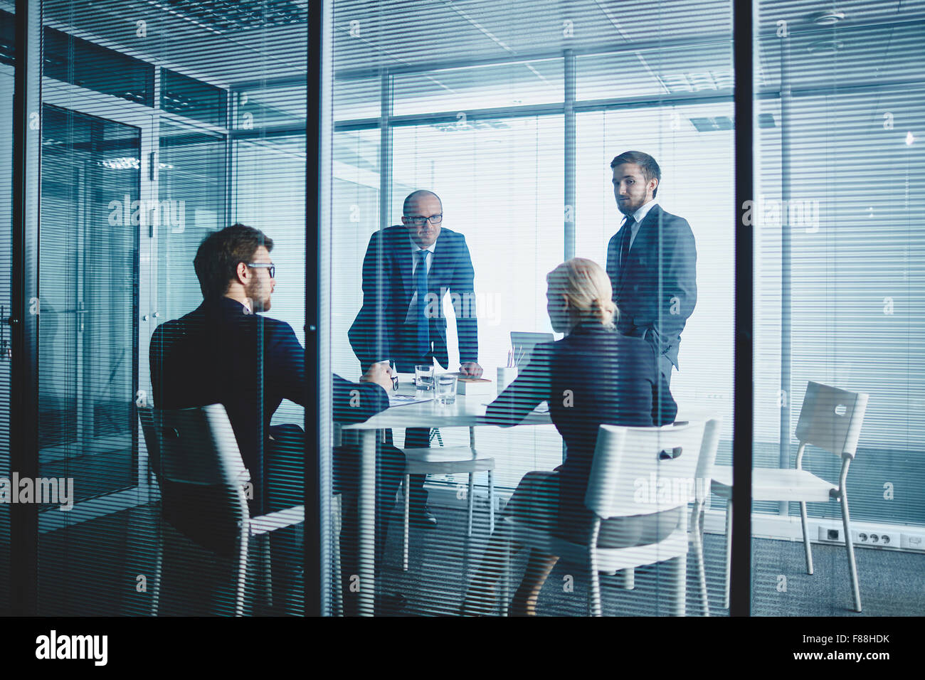 Business team sitting at the table and having meeting Stock Photo - Alamy