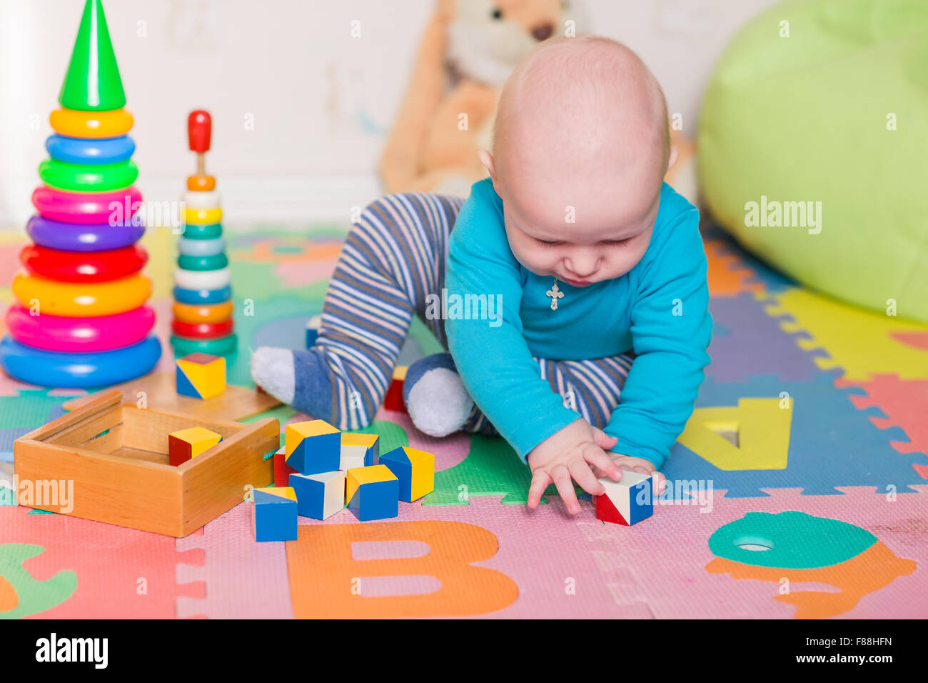 Cute little baby playing with colorful toys Stock Photo - Alamy