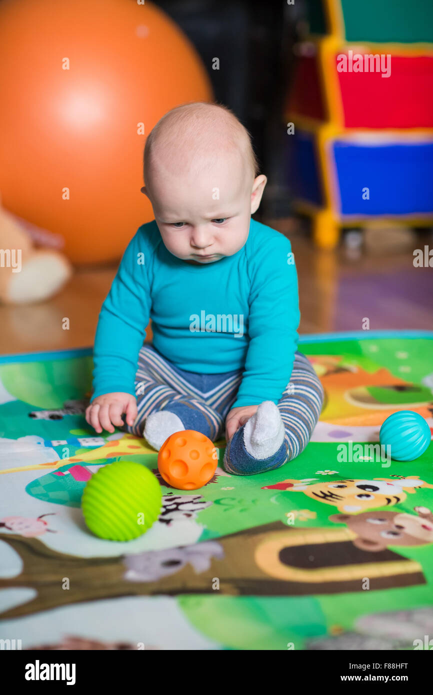 Cute little baby playing with colorful toys Stock Photo - Alamy