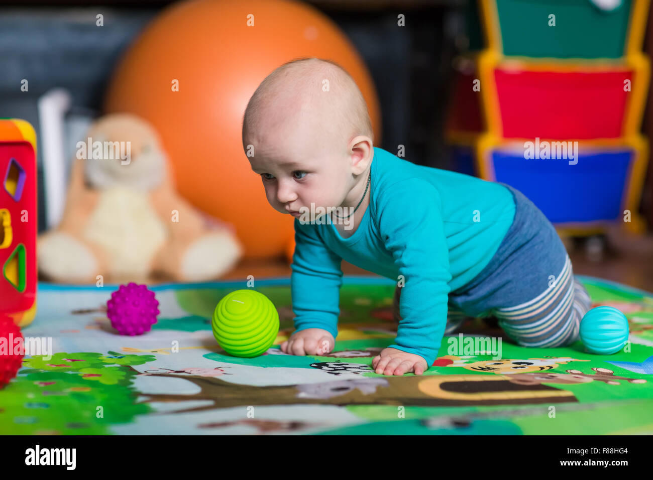 Cute little baby playing with colorful toys Stock Photo - Alamy
