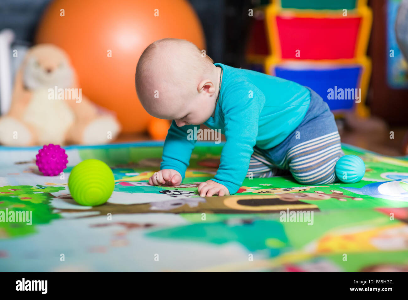 Cute little baby playing with colorful toys Stock Photo - Alamy