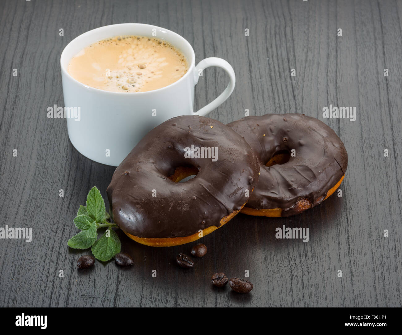 Chocolate donuts with coffee on the desk Stock Photo - Alamy